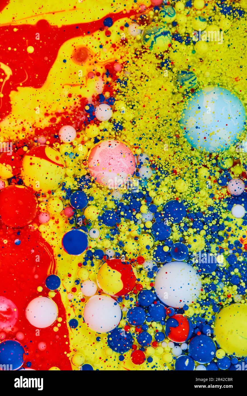 Vertical of red and yellow acrylic painting with bubbles and flecks of ...
