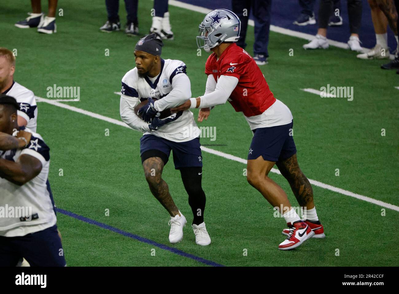 Dallas Cowboys running back Tony Pollard, left, grabs a handoff from ...
