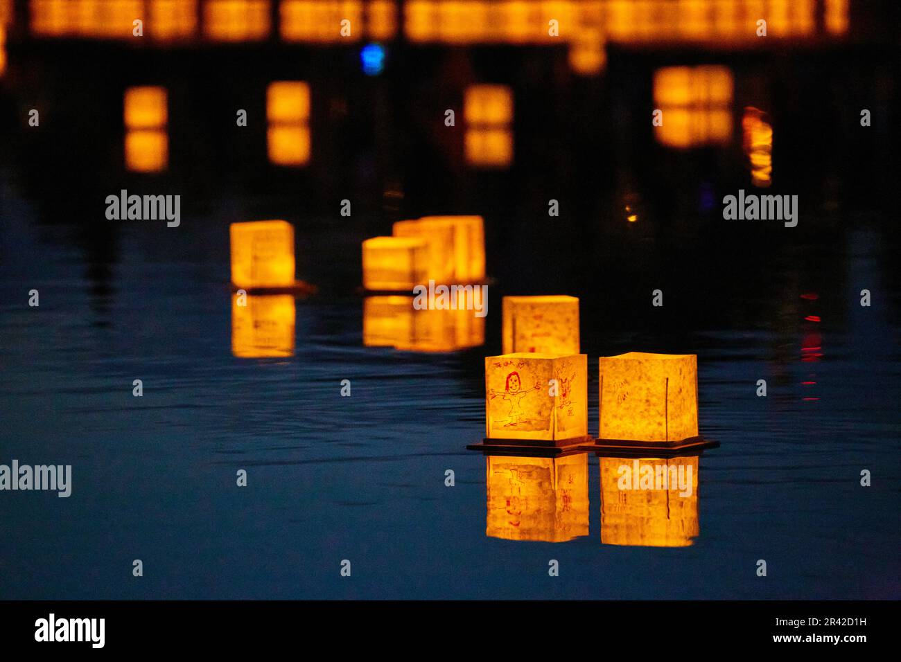 Calm deep dark blue pond with golden lanterns Stock Photo - Alamy