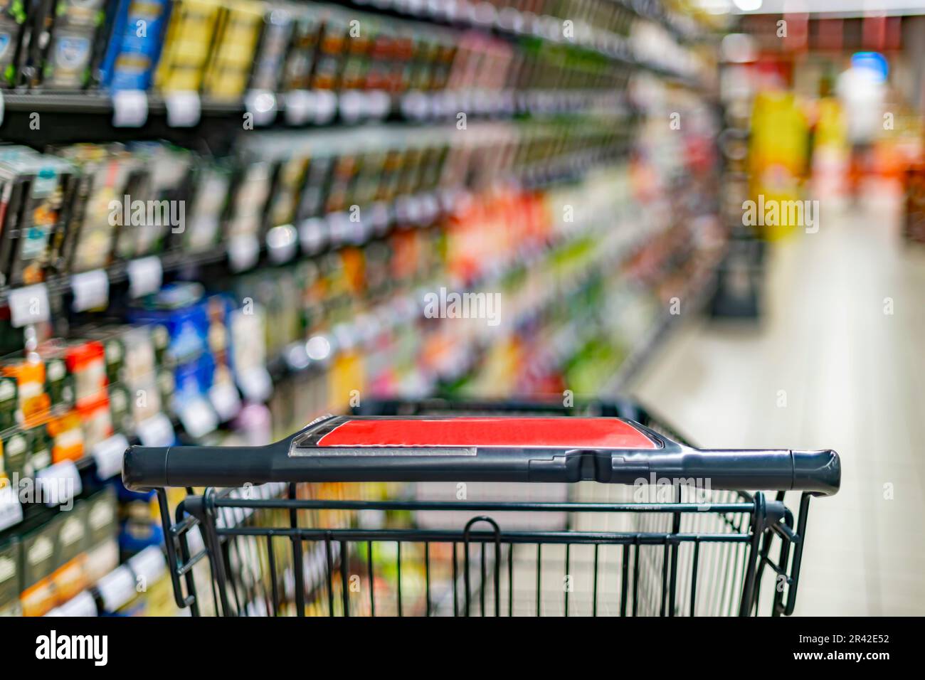 A shopping cart by a store shelf in a supermarket Stock Photo - Alamy