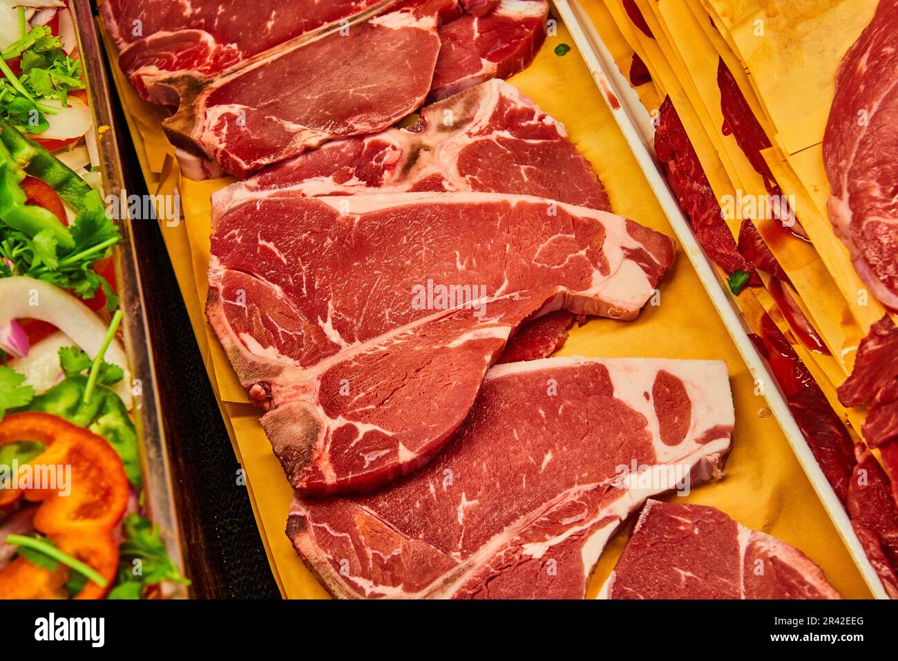Horizontal row of raw t-bone steaks asset Stock Photo - Alamy