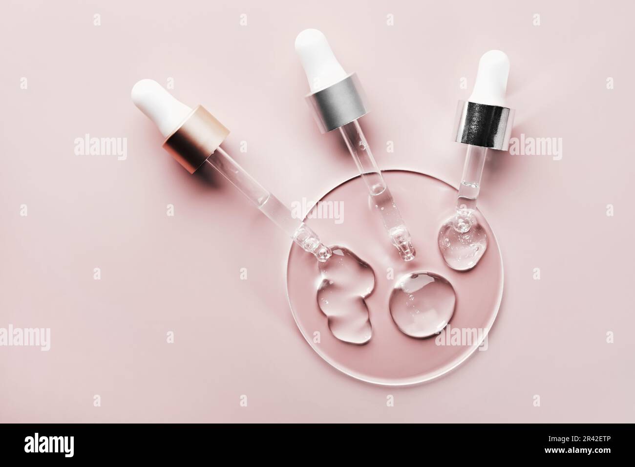 Three pipettes with different samples of gels cosmetic products in ...