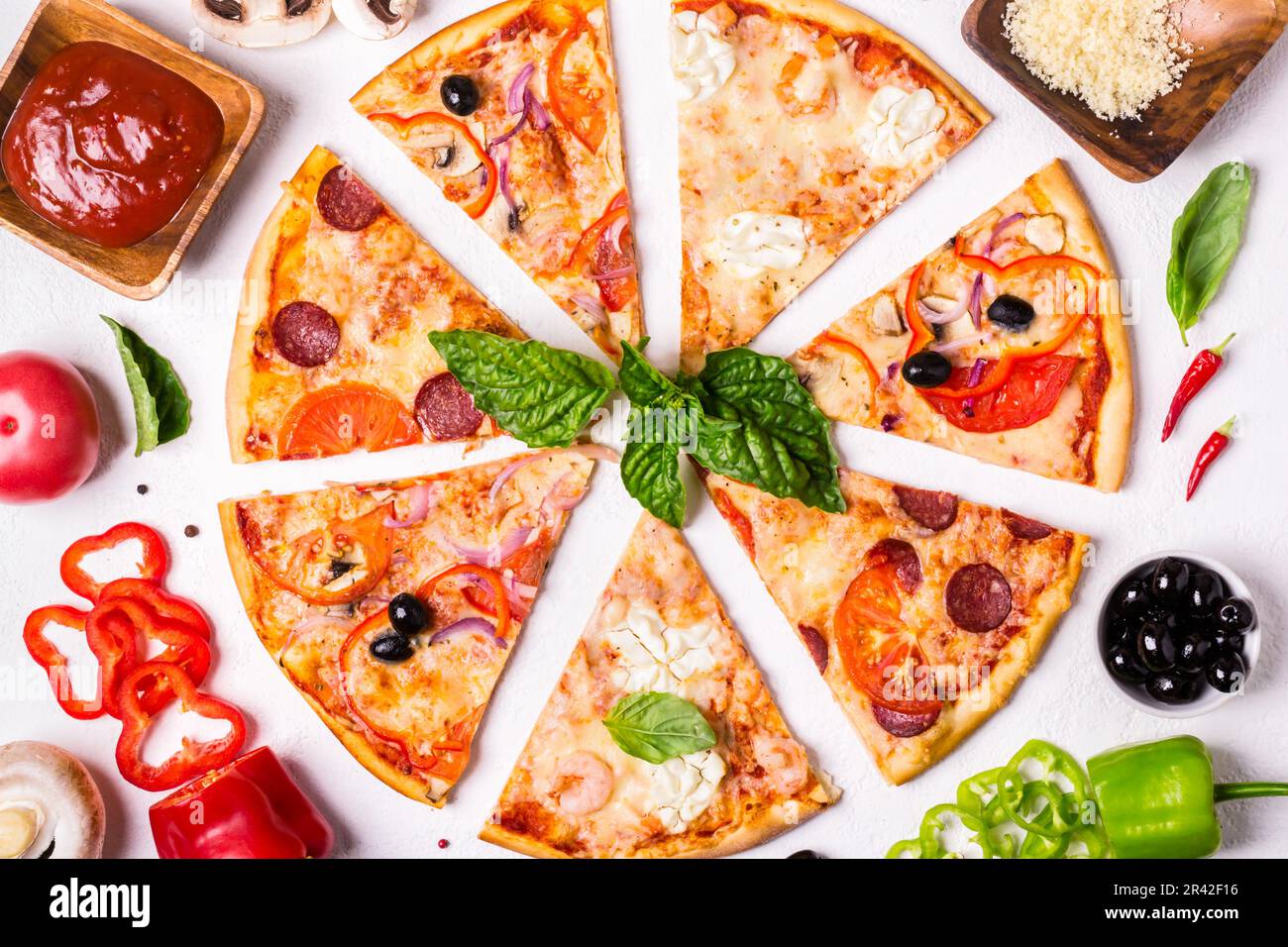 Selection of Assorted pieces pizza on white background and ingredients ...