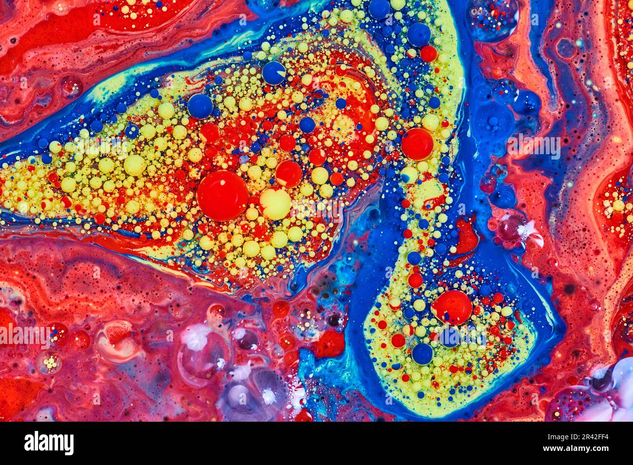 Background asset of swirling blue red and yellow acrylic paint with oil ...