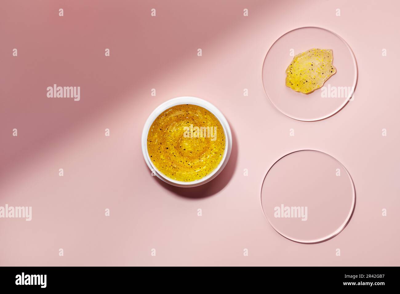 Cosmetic product with particles in container and petri dish on pink ...