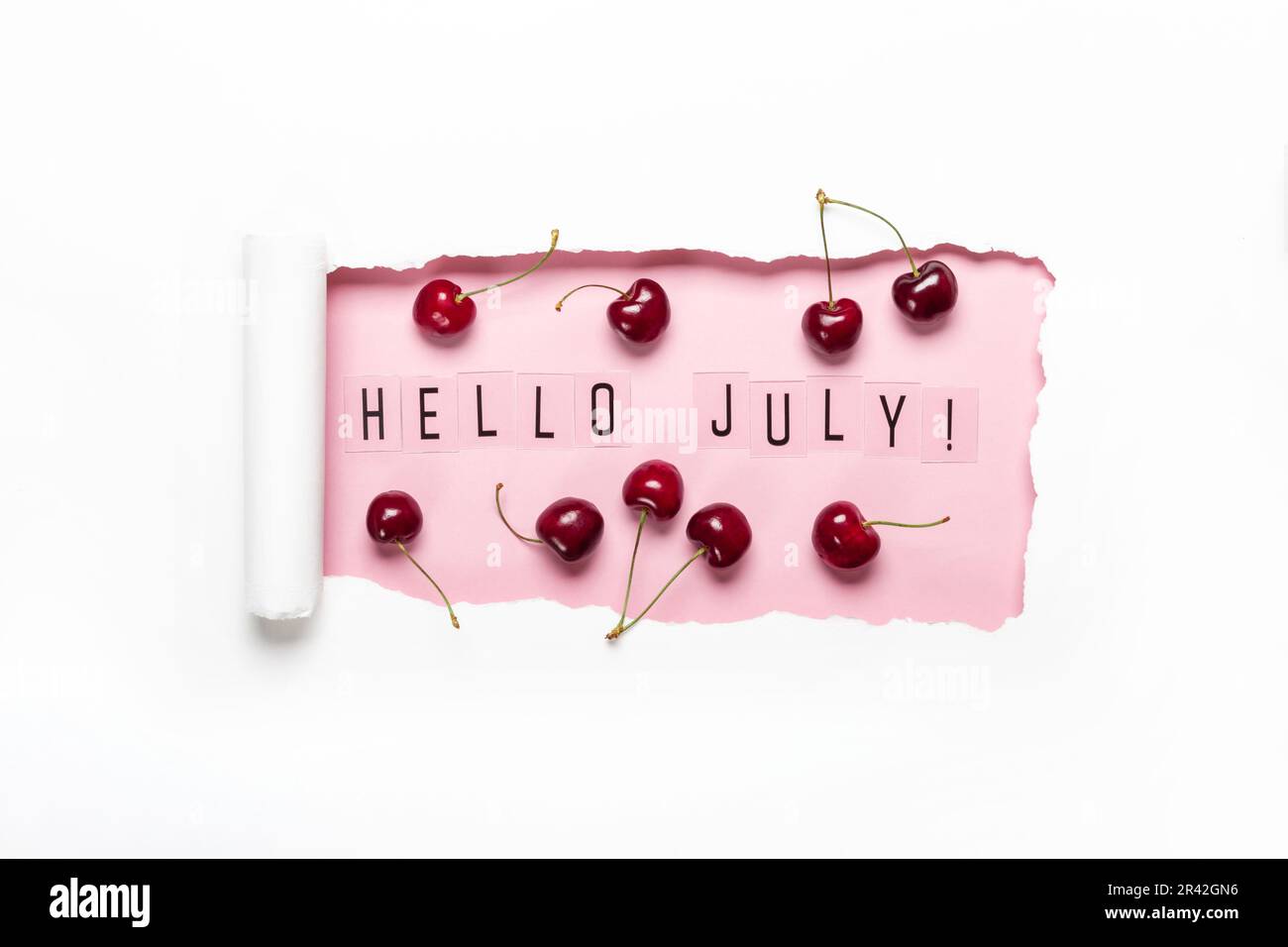 Hello July text and paper hole with cherries on pink background. Hello ...