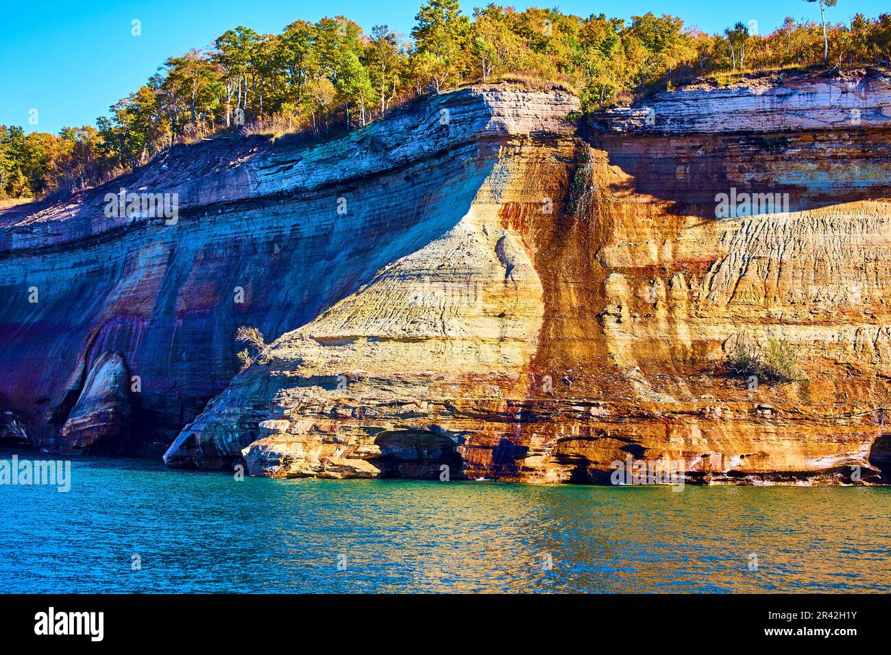 Forest above Pictured Rocks cliff with archway through stone and calm ...