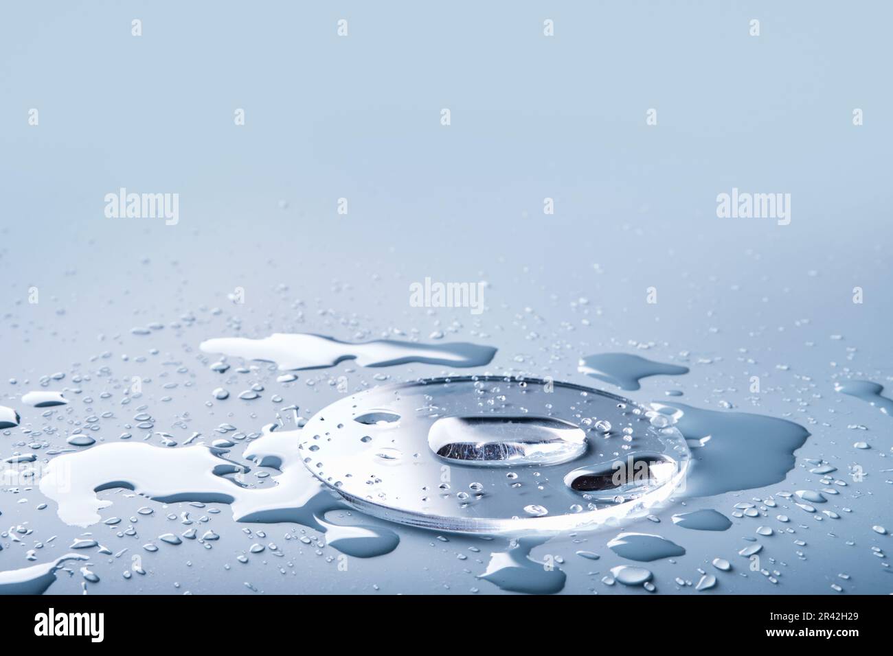 Cosmetic product drops and in glass slide on blue background, selective ...