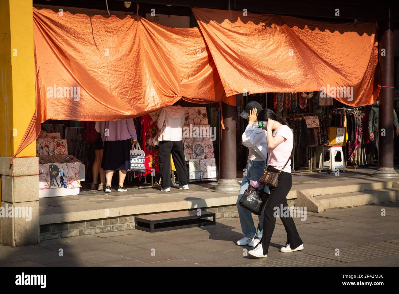 Passerby's walking past shop alongside Xuanmiao Temple Stock Photo - Alamy