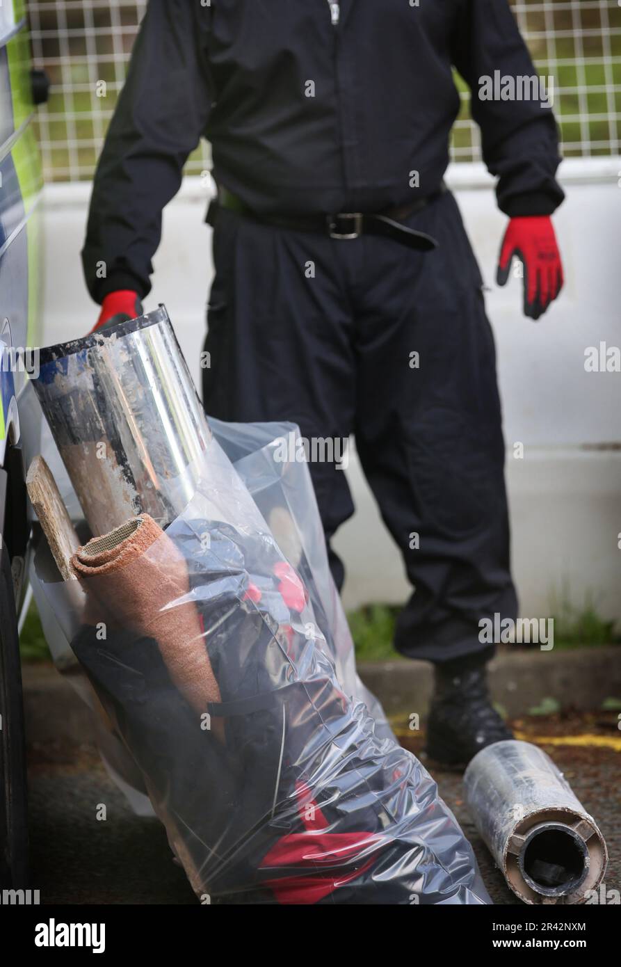 A specialist police officer prepares to take away bagged up evidence ...