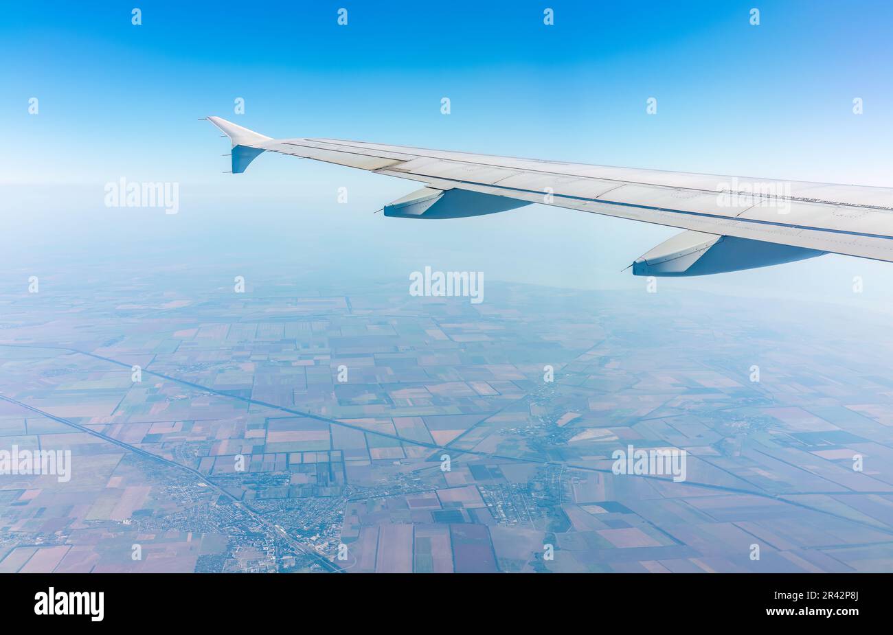 Aerial view from airplane window above green ground. View from the ...