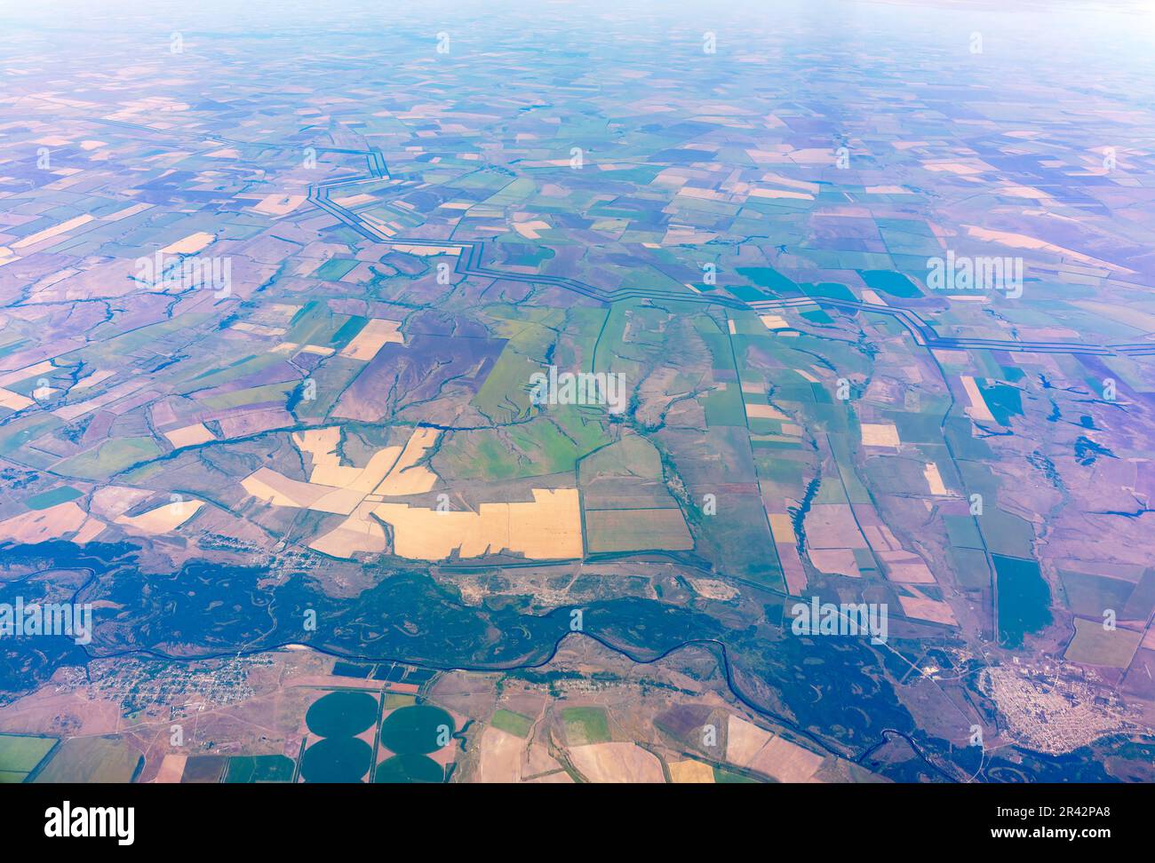 Aerial view from airplane window above green ground. View from the ...