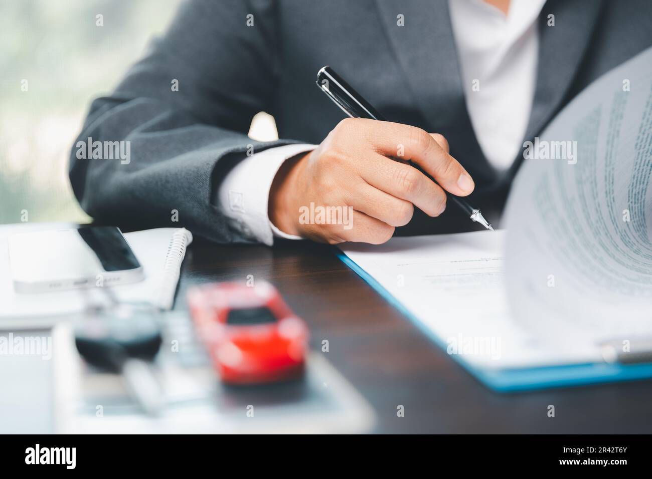 Car dealer business woman signing car insurance document or lease paper ...