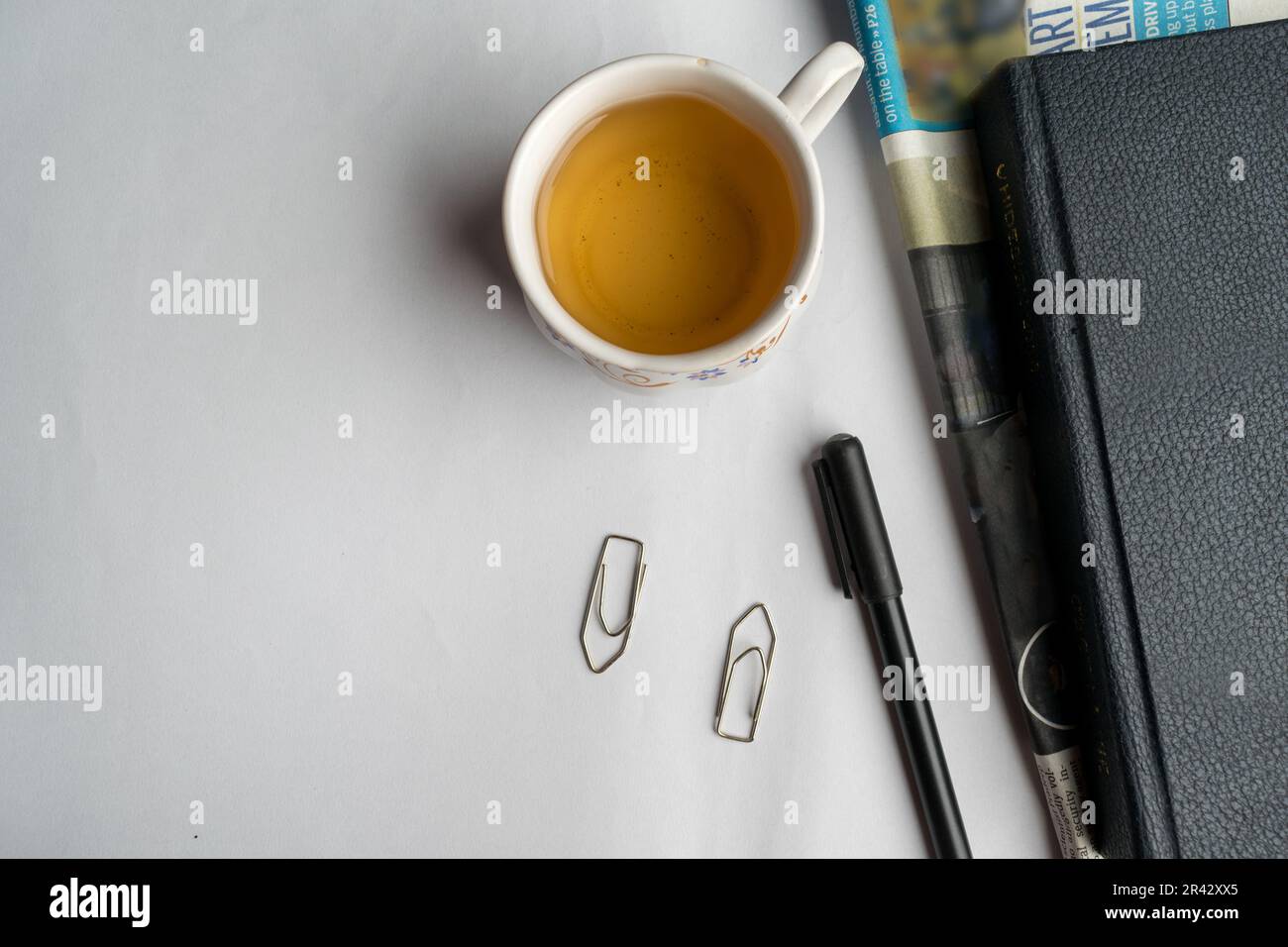 Flat lay design of work desk with teacup, notebook, pen, newspaper, and ...