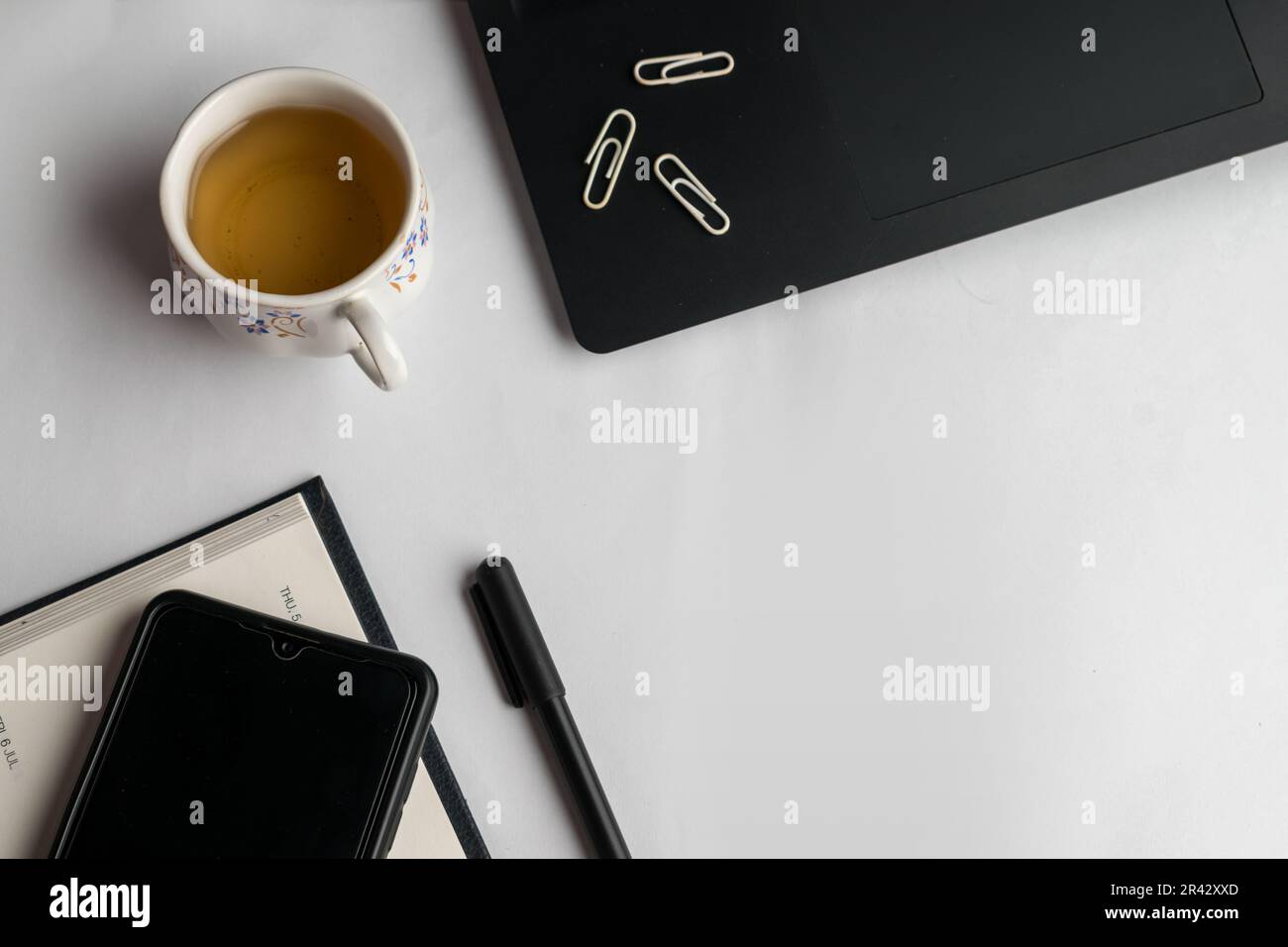 Flat lay design of work desk with notebook, pen, laptop, mobile, teacup ...