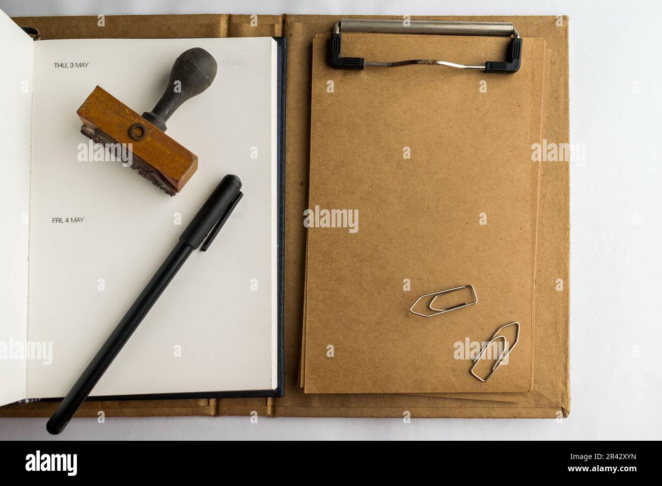 Flat lay design of work desk with notebook, pen, stamp, clipboard, and ...