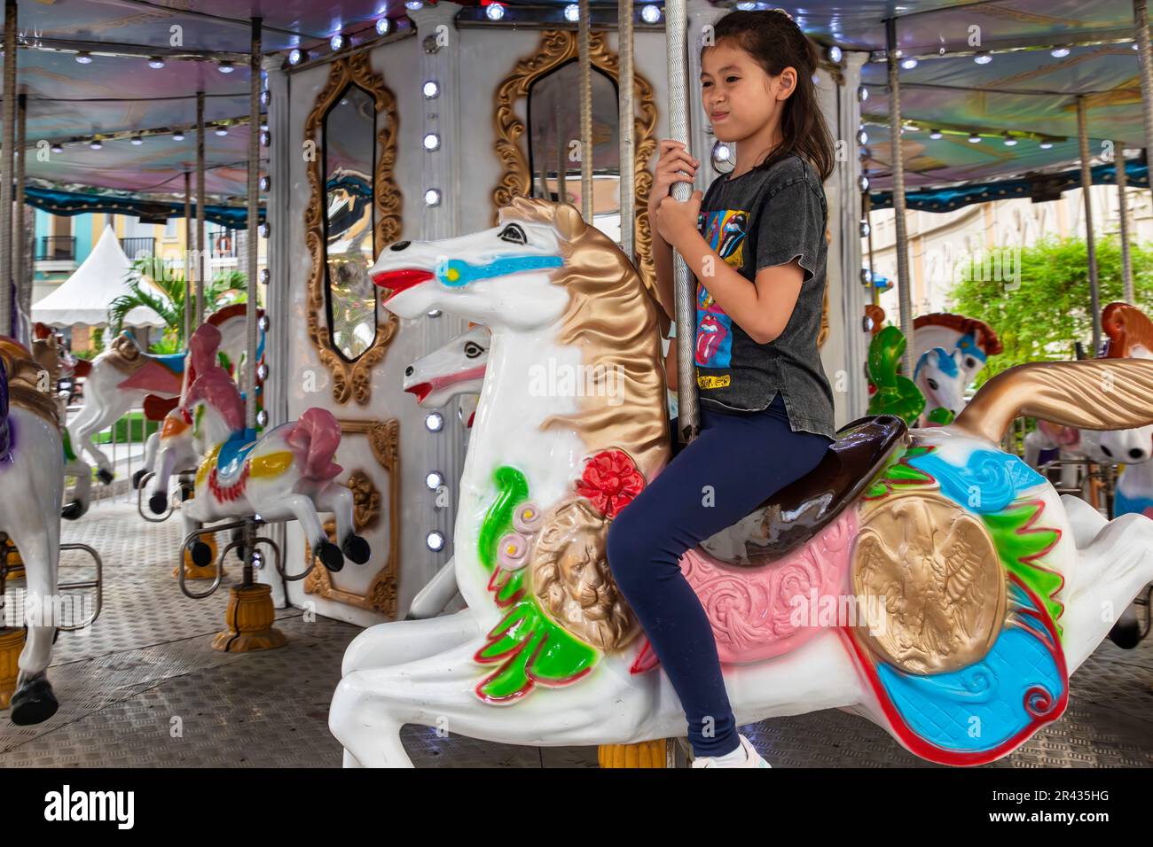 Young Philippina girl on carousel, Venice Grand Canal Mall, Taguig City ...