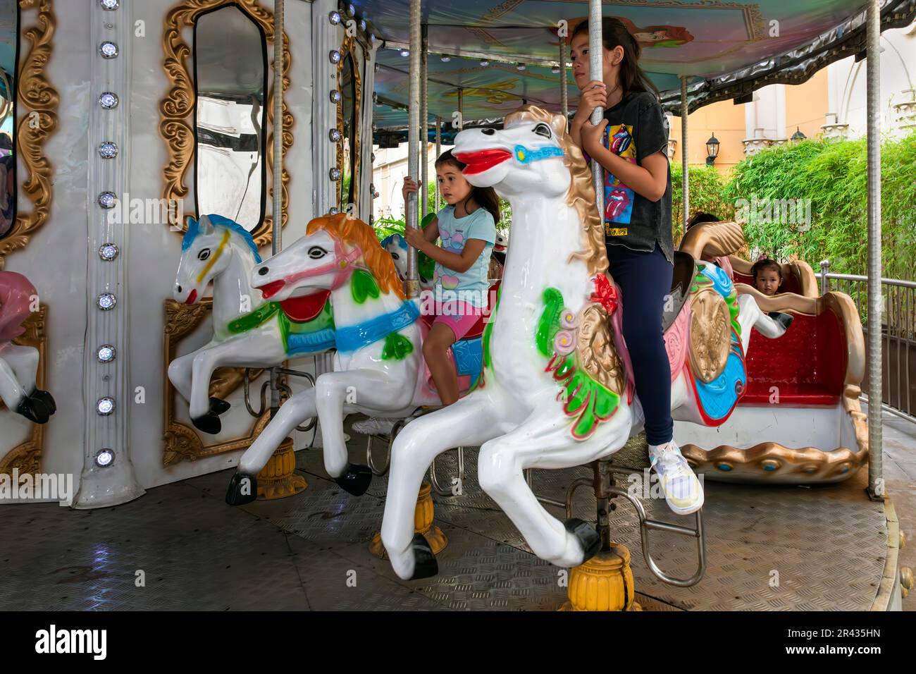 Young Philippina girl on carousel, Venice Grand Canal Mall, Taguig City ...