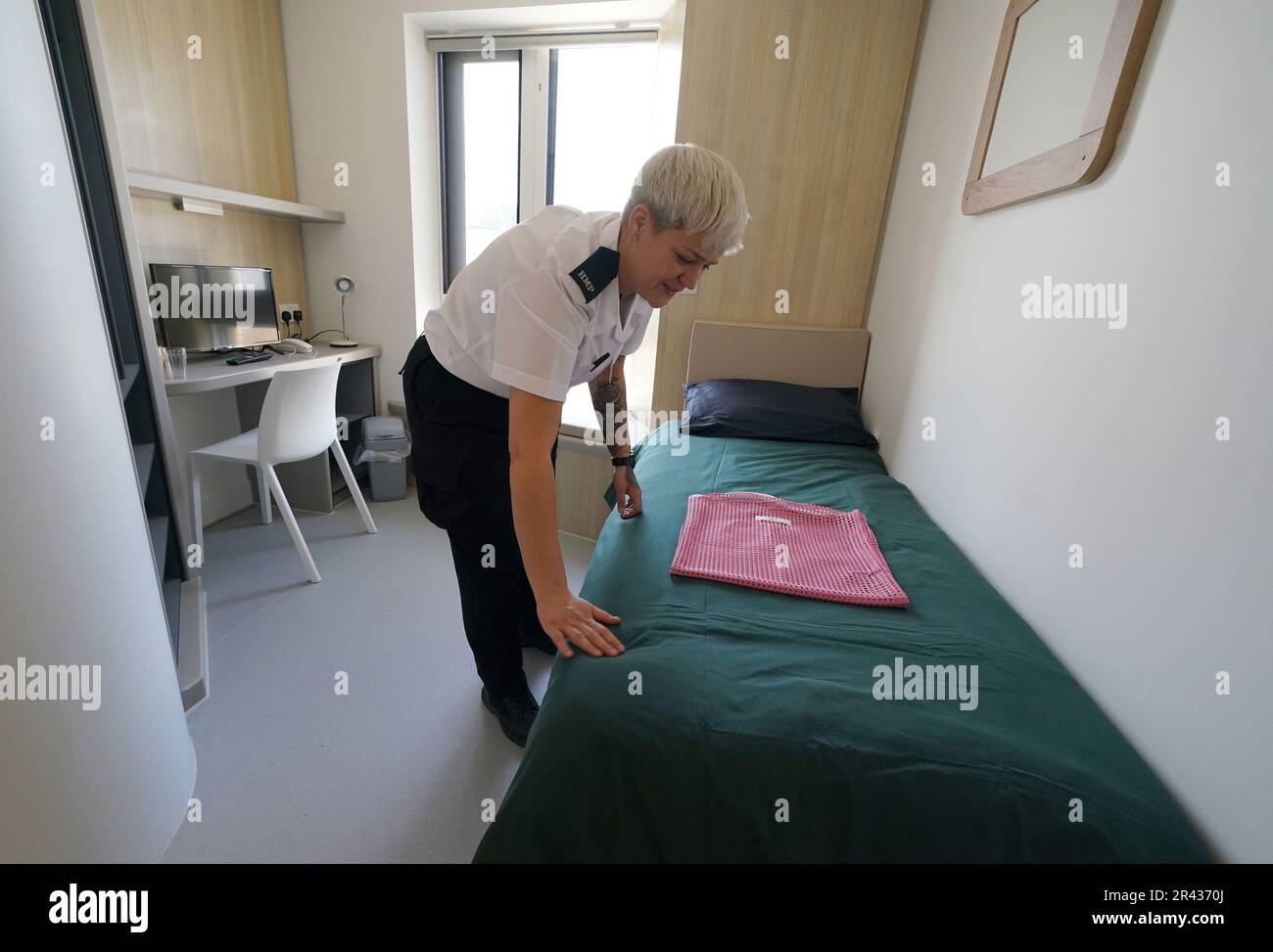 A prison officer adjusts the bedding inside a room within Iris House ...