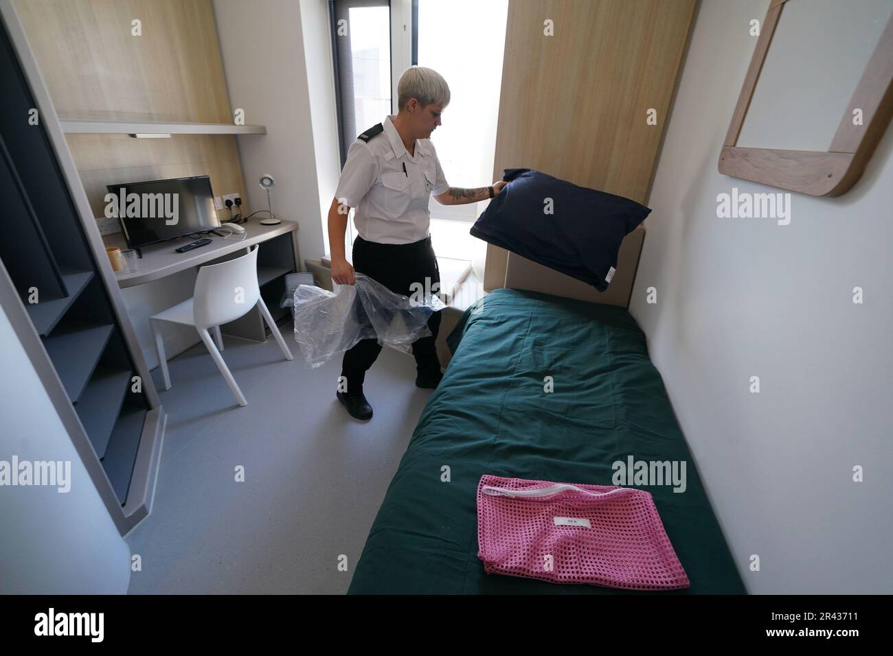 A prison officer adjusts the bedding inside a room within Iris House ...