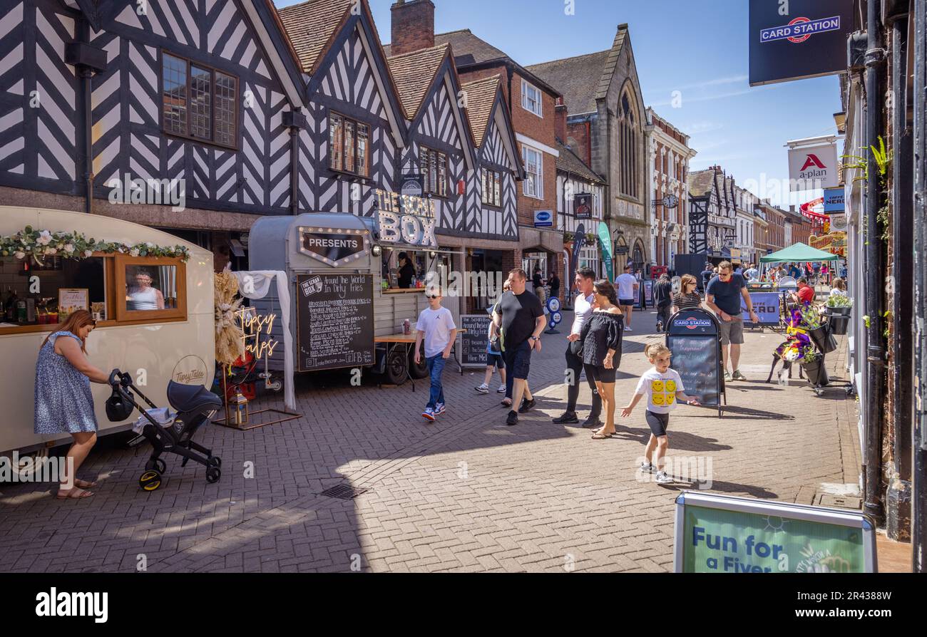 People enjoying the sun while walking along a busy street lined with ...