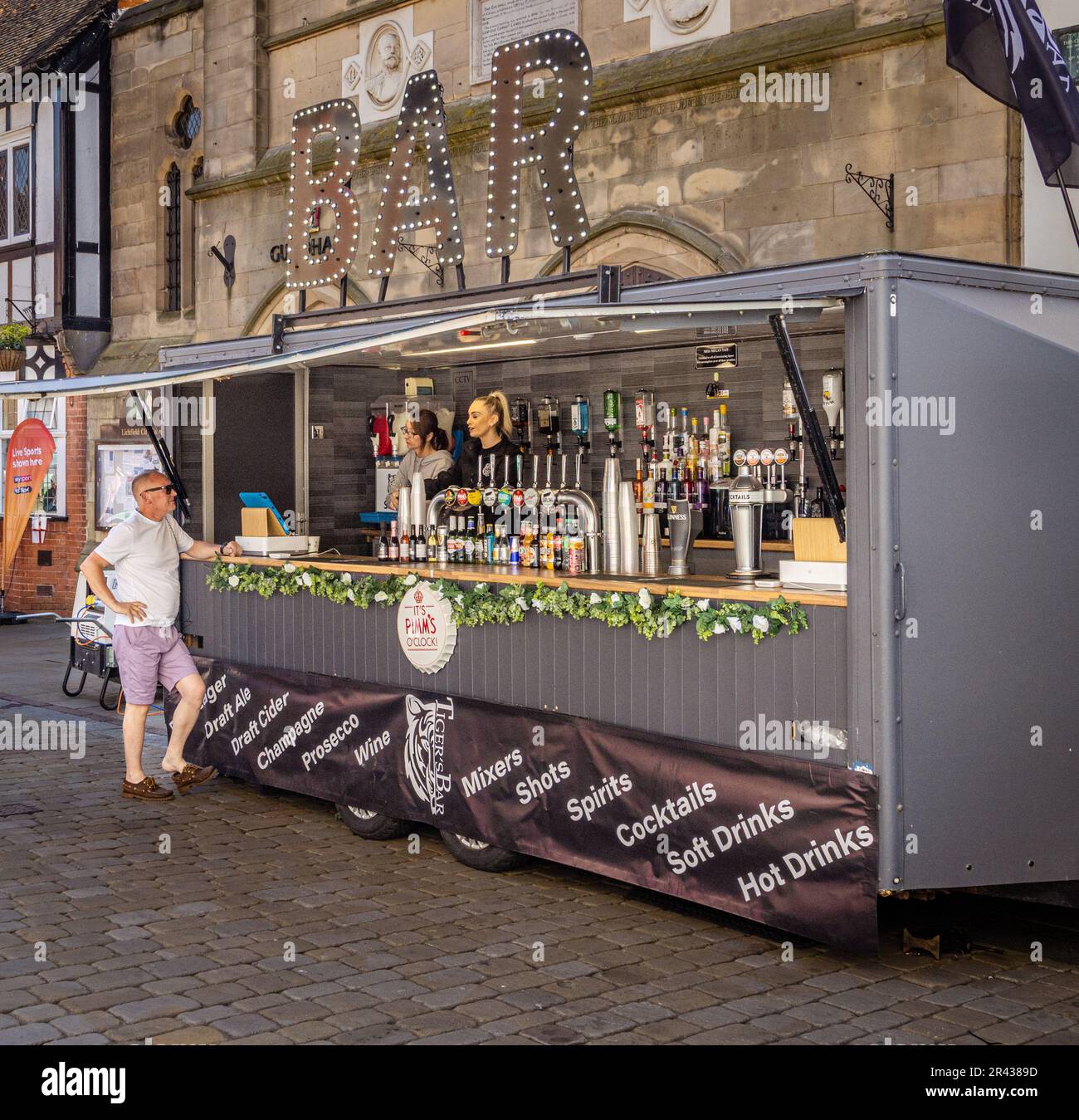 A man talking to the bar staff at a pop up bar during Lichfield food ...