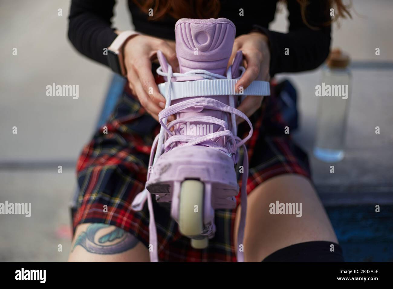 Roller blader girl putting on aggressive inline skates. Young skater ...