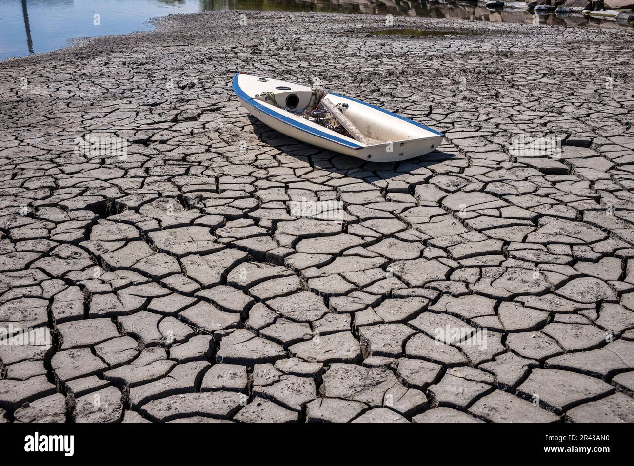 Boat on a dried up riverbed with cracked surface Stock Photo - Alamy