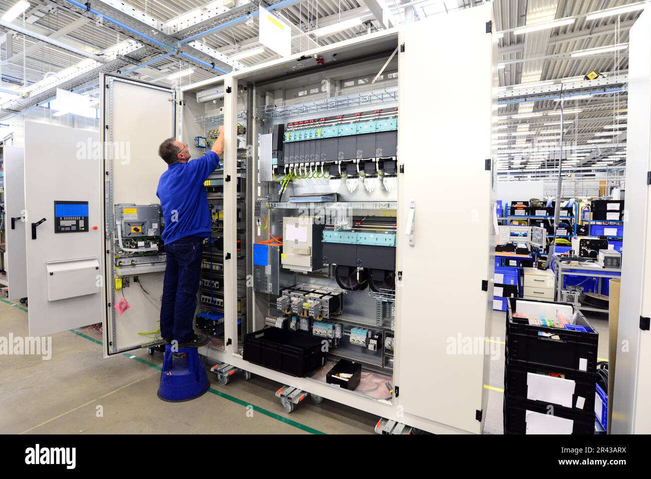 operator assembles machine in a factory - production of switch cabinets ...