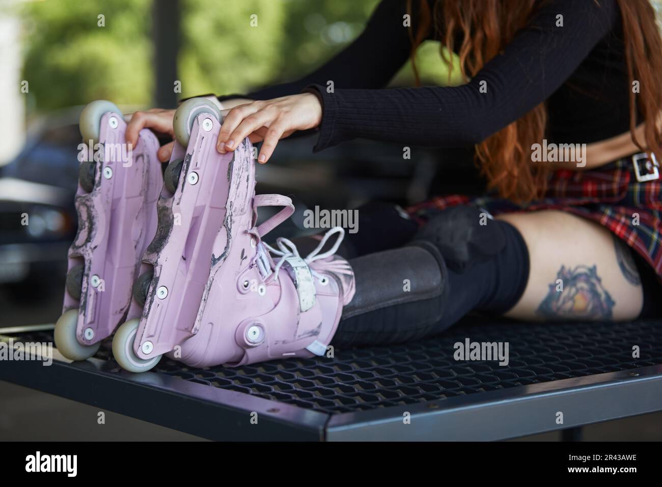 Skater girl stretching before the ride on aggressive inline skates ...