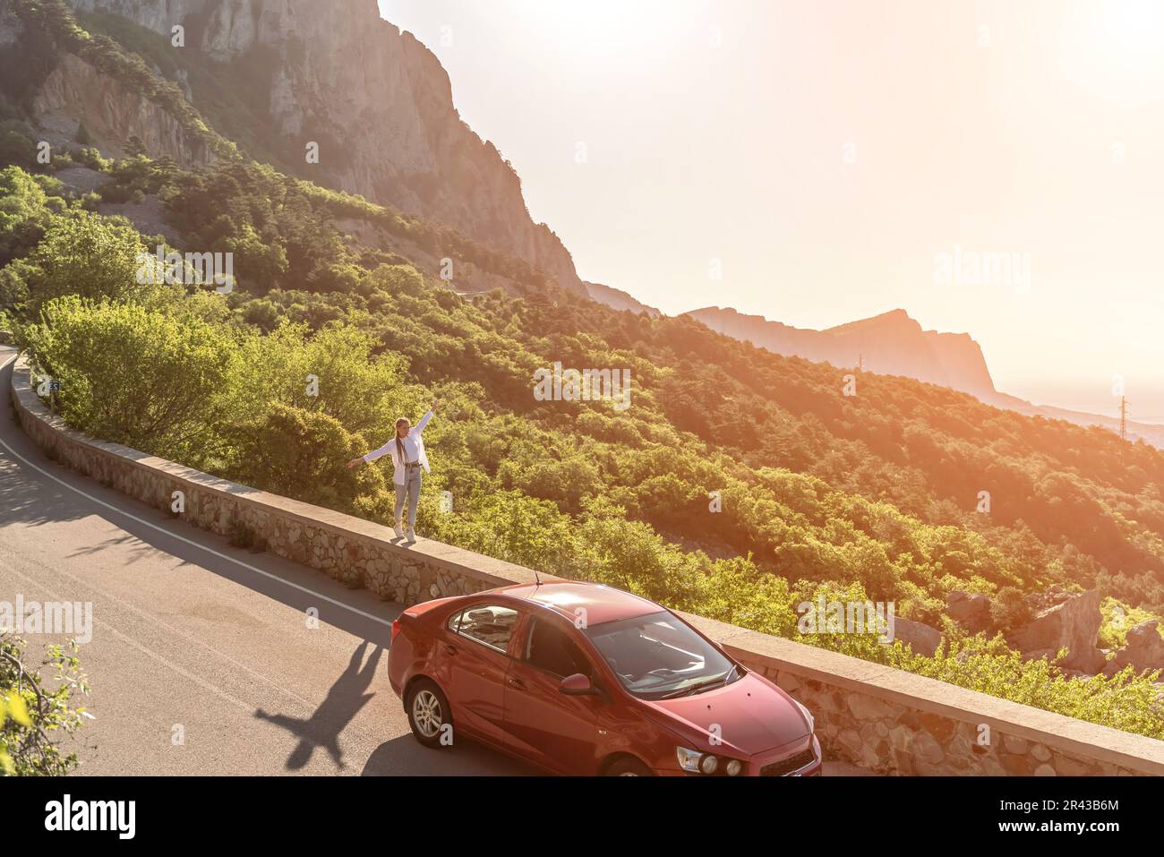 Mountain road woman. She walks along a parapet road in the middle of a ...