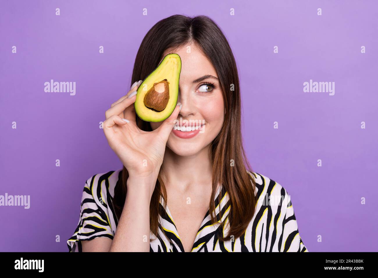 Photo of cute funky lady hold half avocado look empty space beaming ...