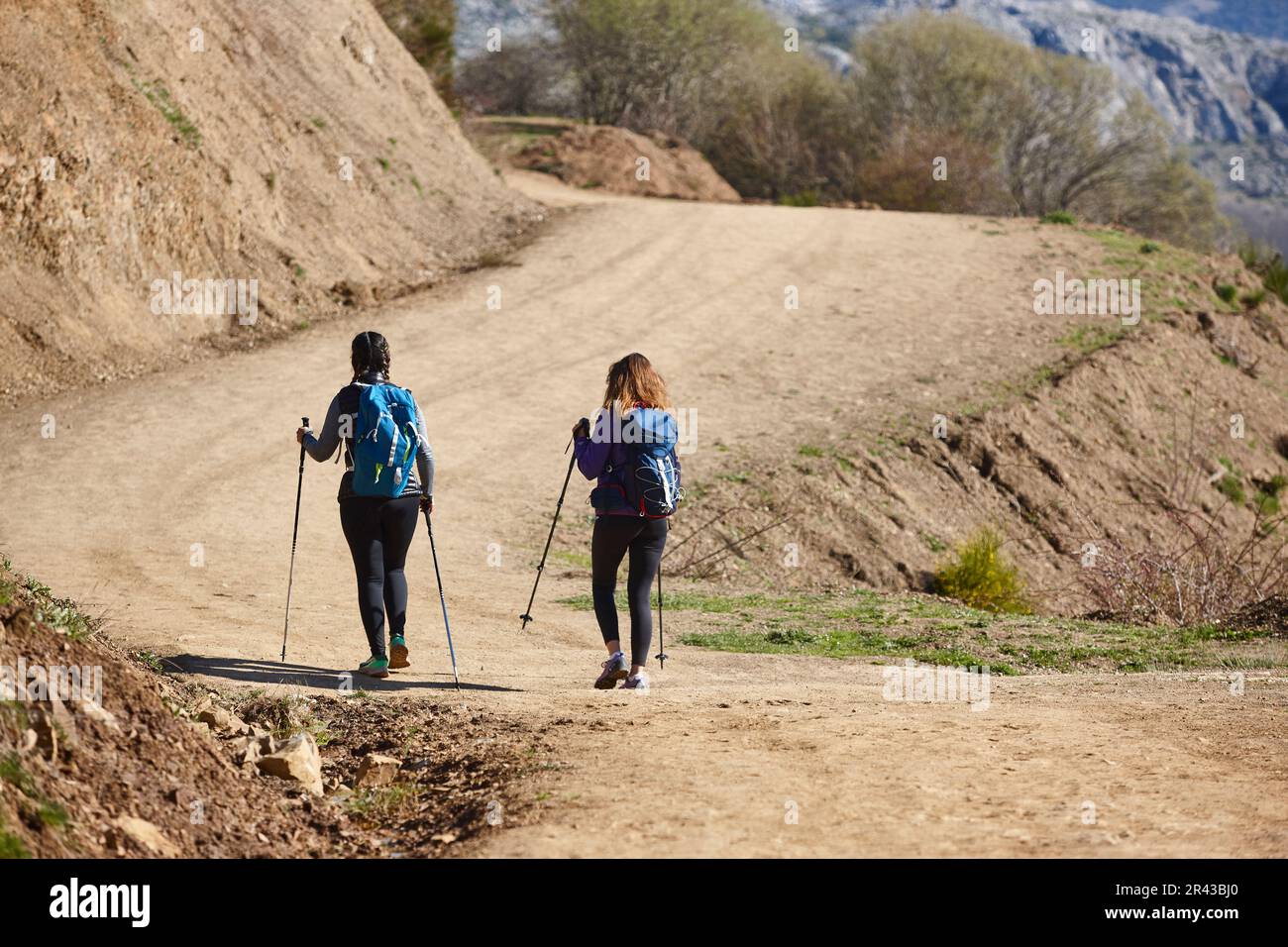 Two female backpacker hikers on a pathway. Outdoor healthy lifestyle ...