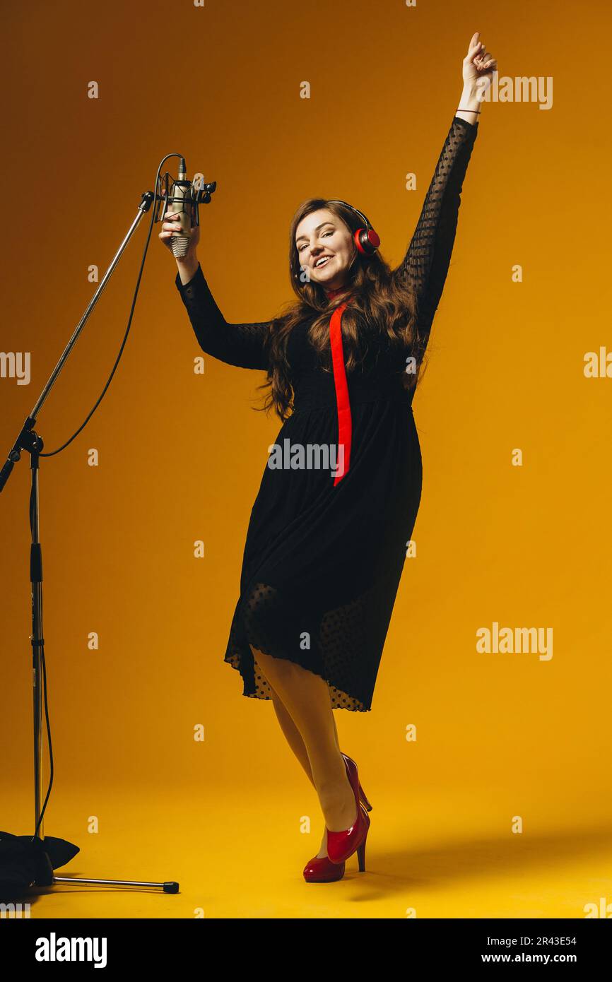 The positive amusing brunette female singer having fun sings song ...