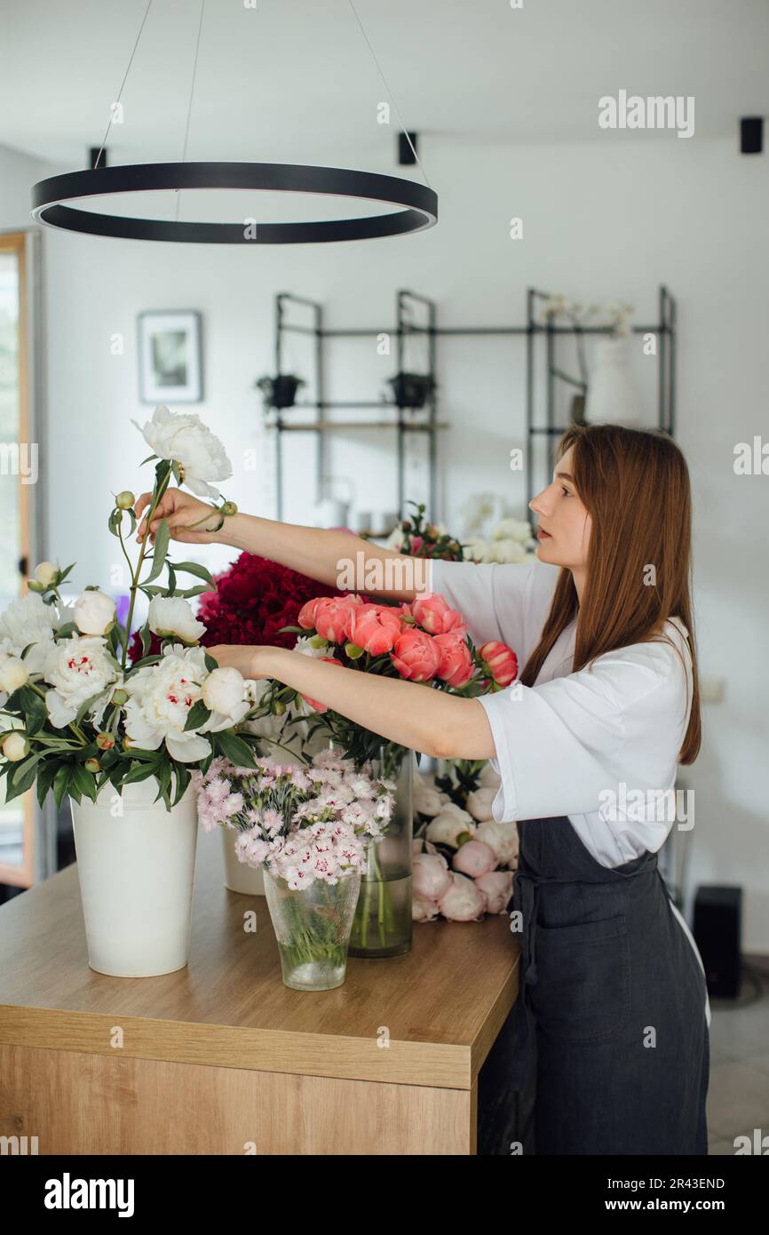 Florist woman in workspace of flower shop. - stock photo Stock Photo ...