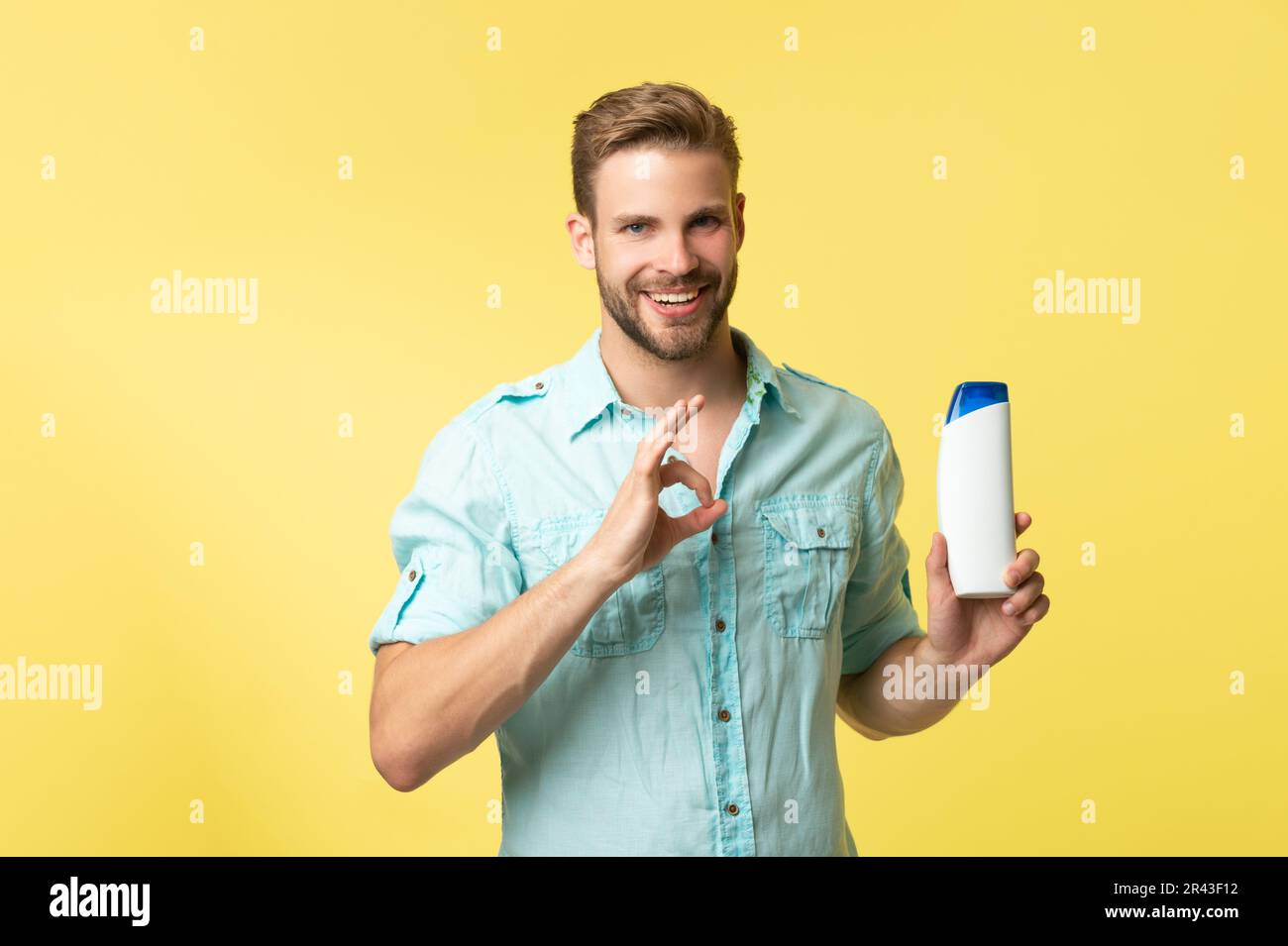 happy man hold shampoo cosmetics in studio background Stock Photo - Alamy