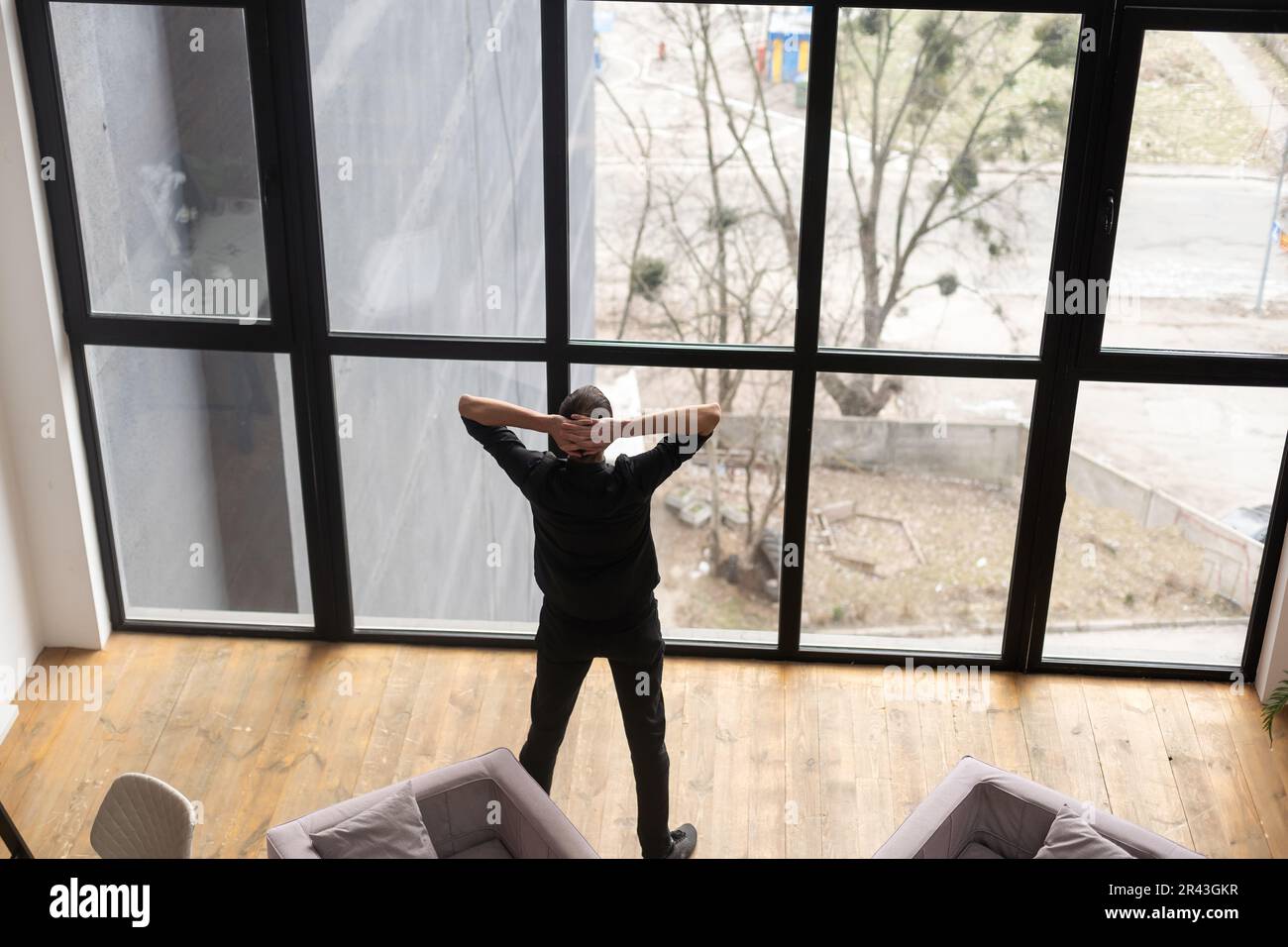 Happy businessman in office looking out the window Stock Photo - Alamy