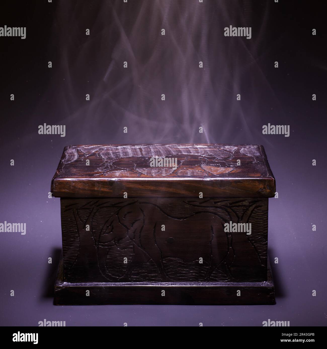 Ancient African box made of wood with light from the top and smoke ...