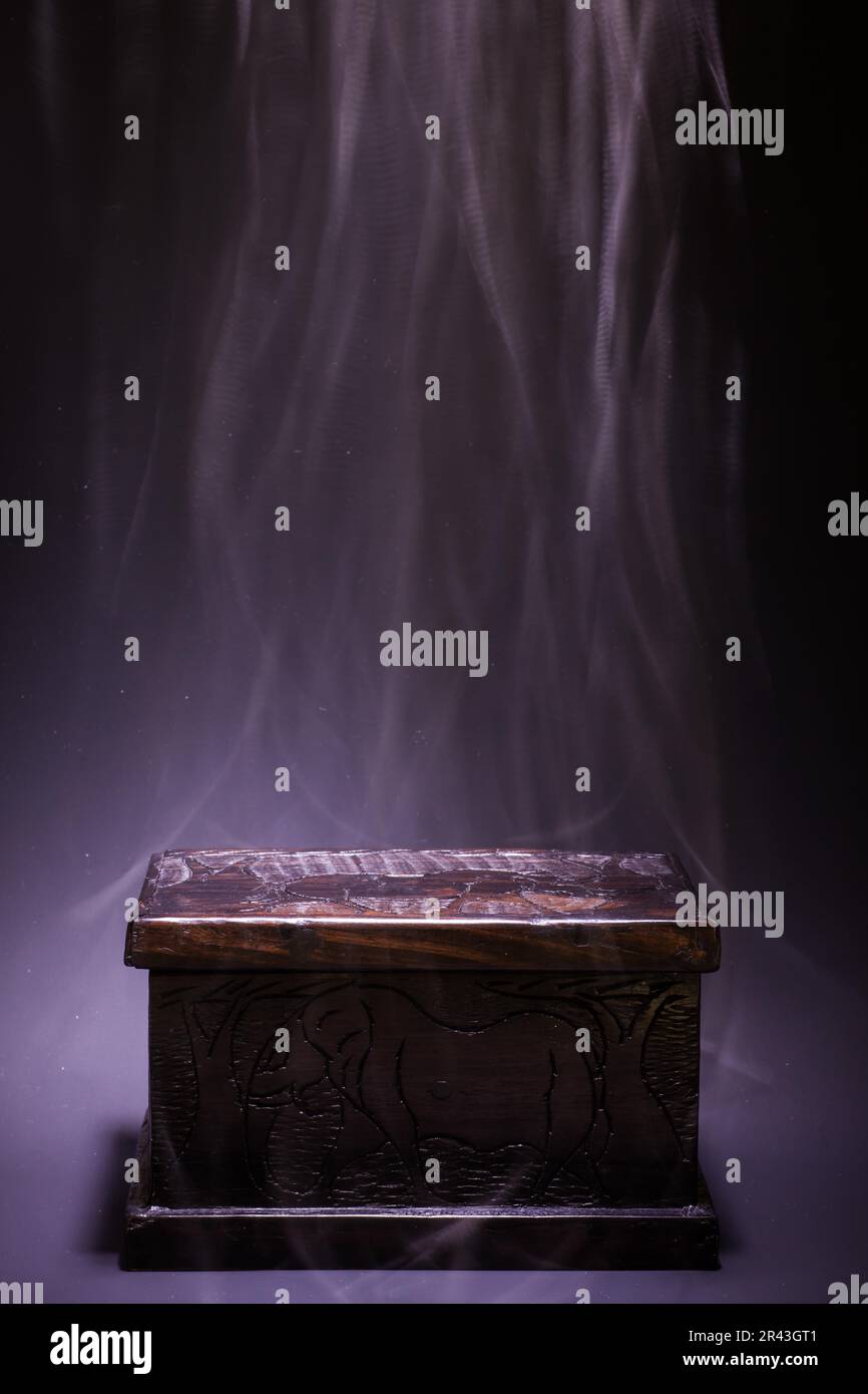 Ancient African box made of wood with light from the top and smoke ...