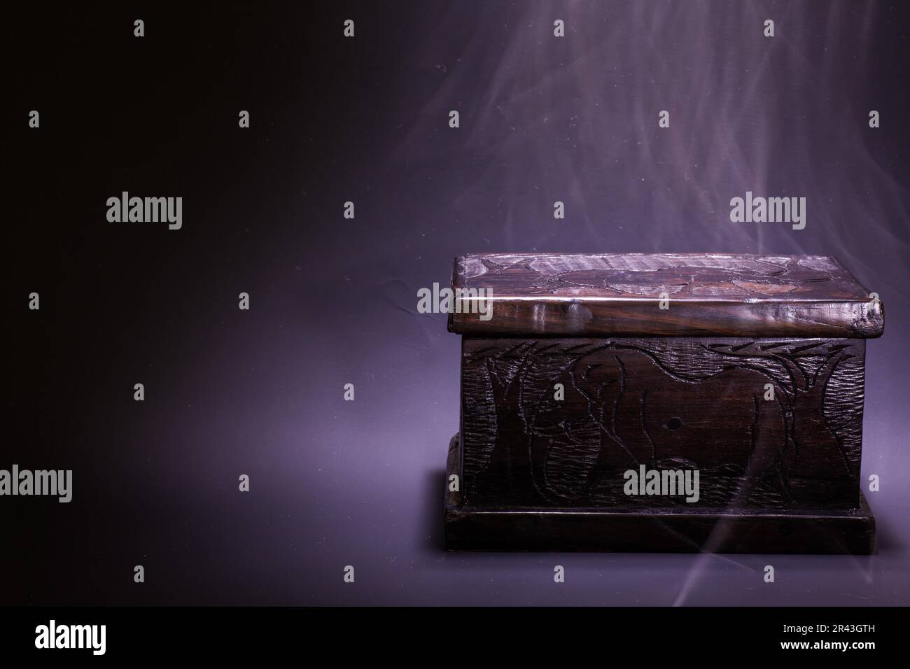 Ancient African box made of wood with light from the top and smoke ...