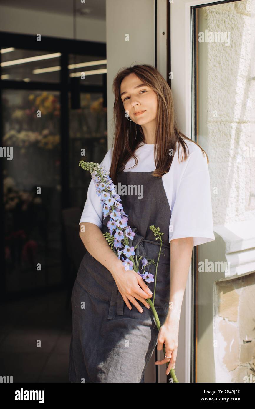 Florist girl with Delphinium flowers near a flower shop Stock Photo - Alamy
