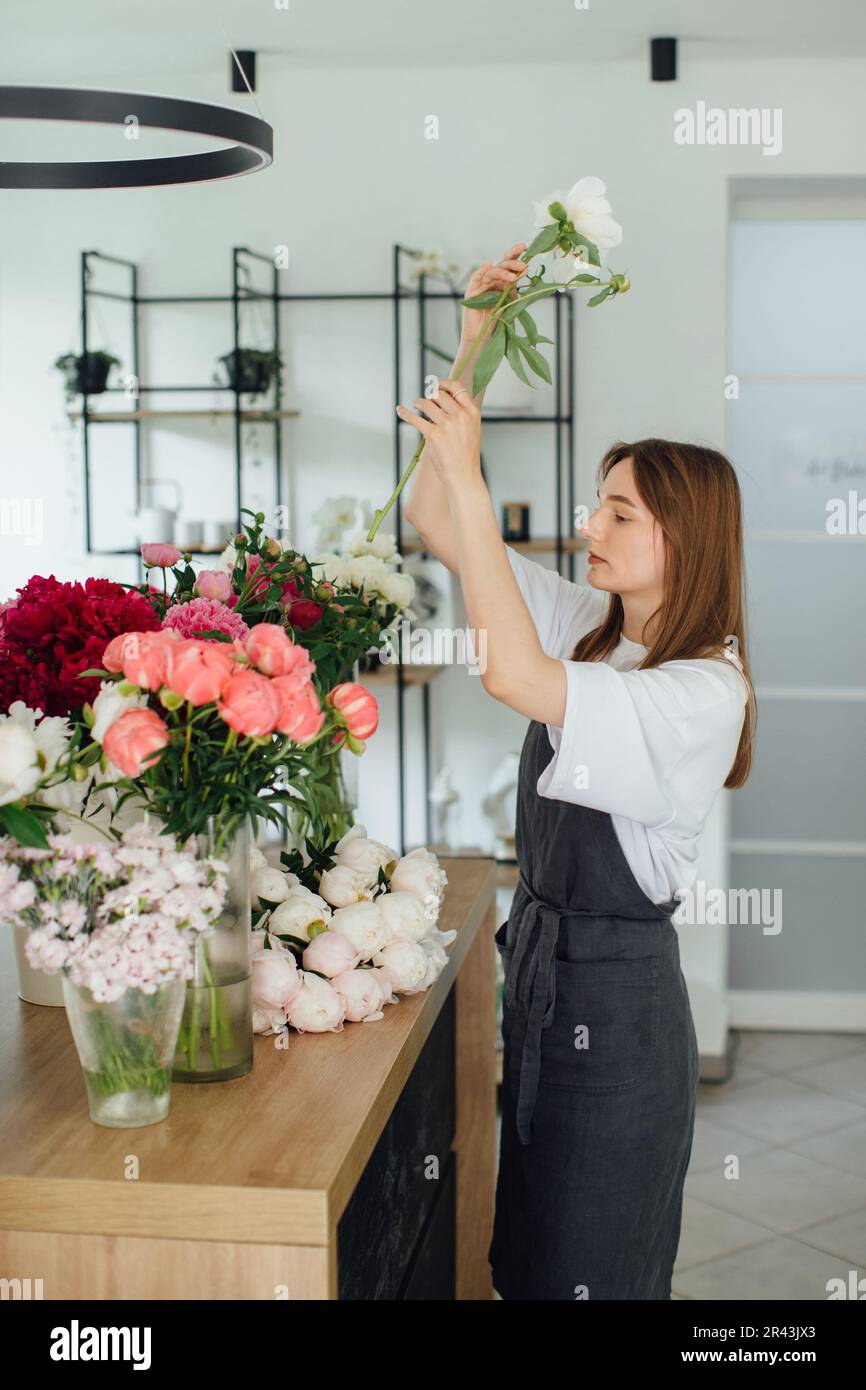 Florist woman in workspace of flower shop. - stock photo Stock Photo ...