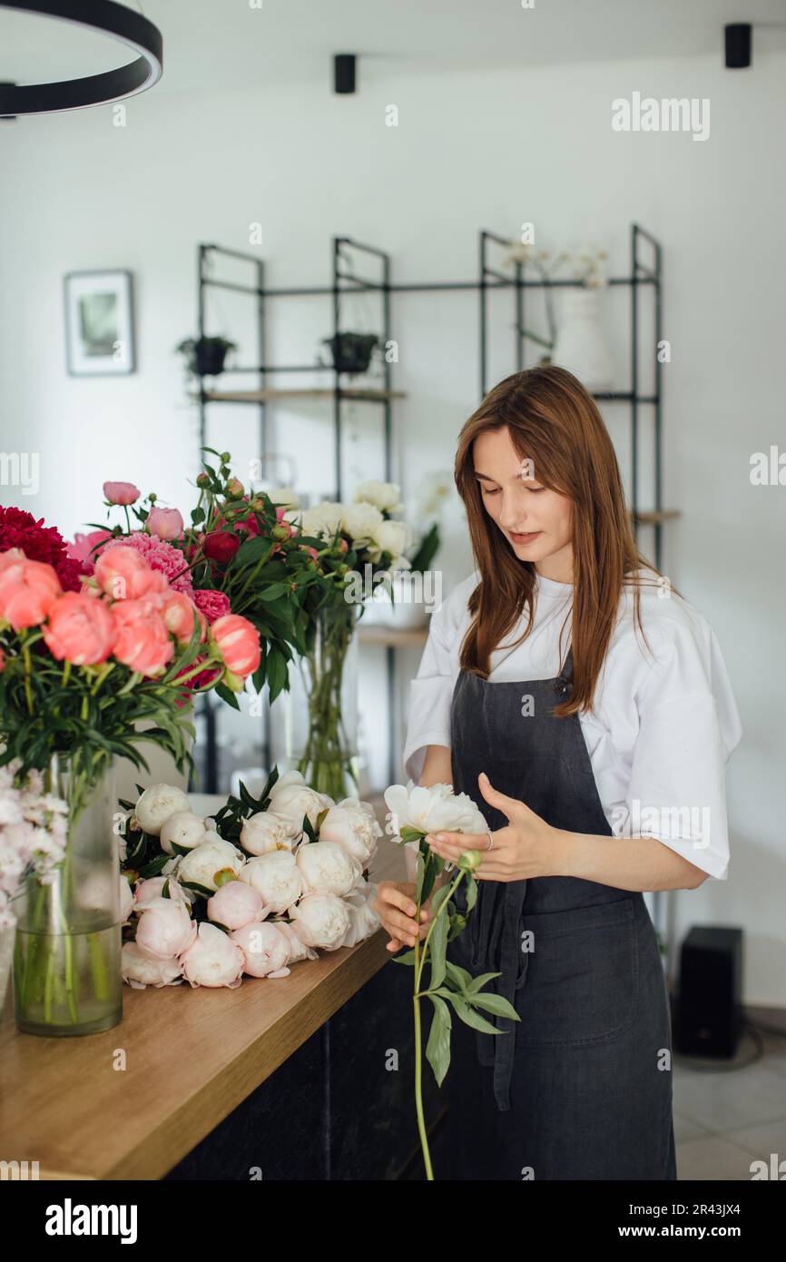 Florist woman in workspace of flower shop. - stock photo Stock Photo ...