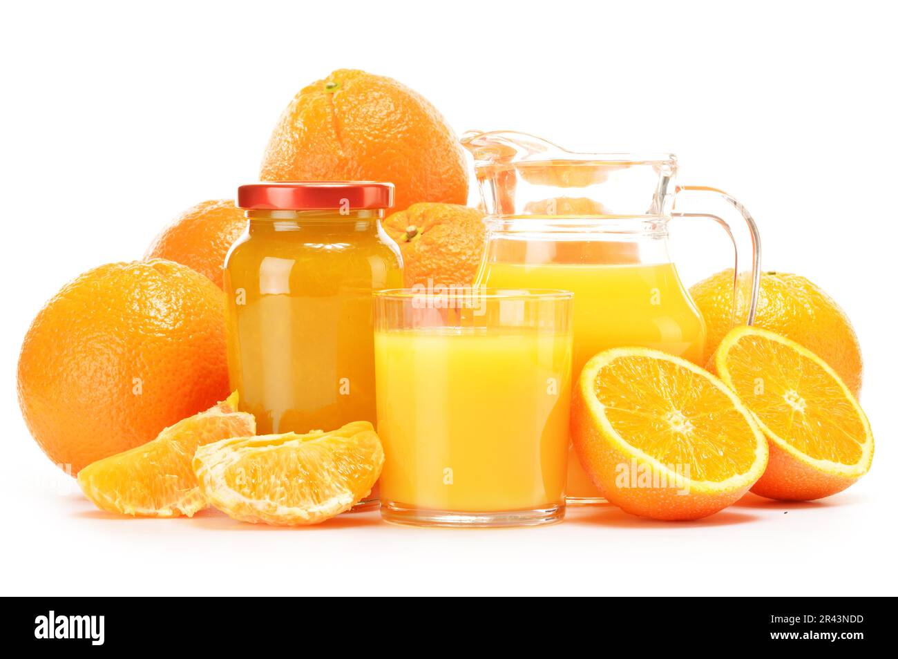 Glass and jug of orange juice, jar of jam and fruits. Variety of orange ...