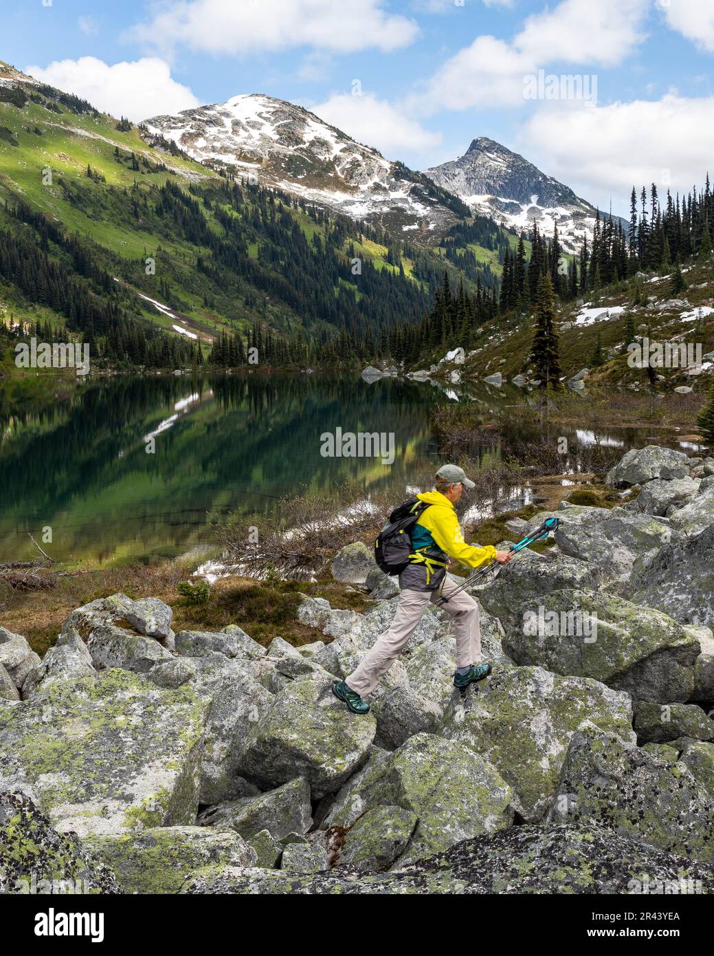 Side view of women hiking backed by alpine lake and mountains Stock ...