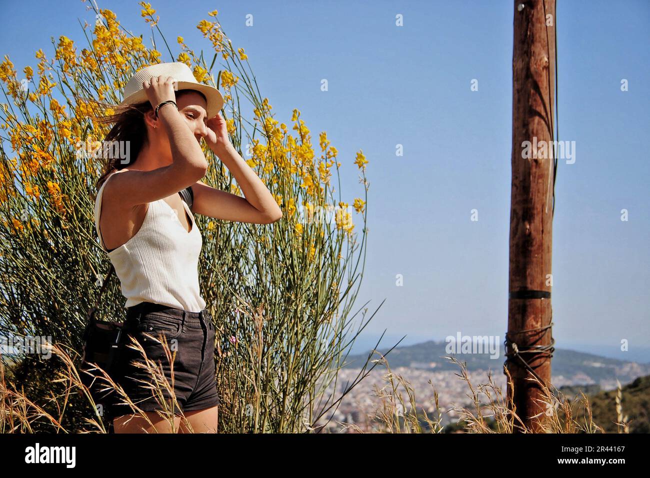 Girl dressed in white putting on her hat Stock Photo - Alamy