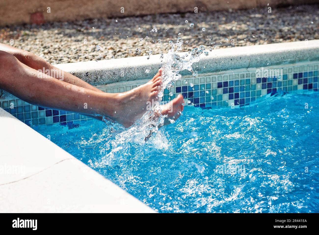 Person splashing in the pool with his feet Stock Photo - Alamy