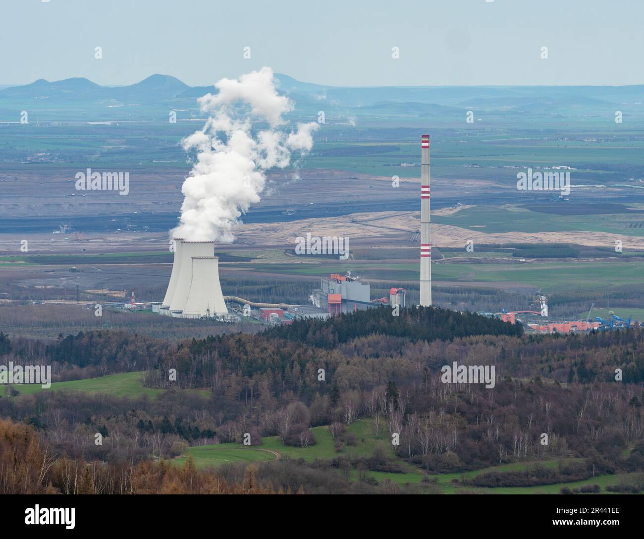 Smoking coal fired power plant and steam rising from a cooling tower ...