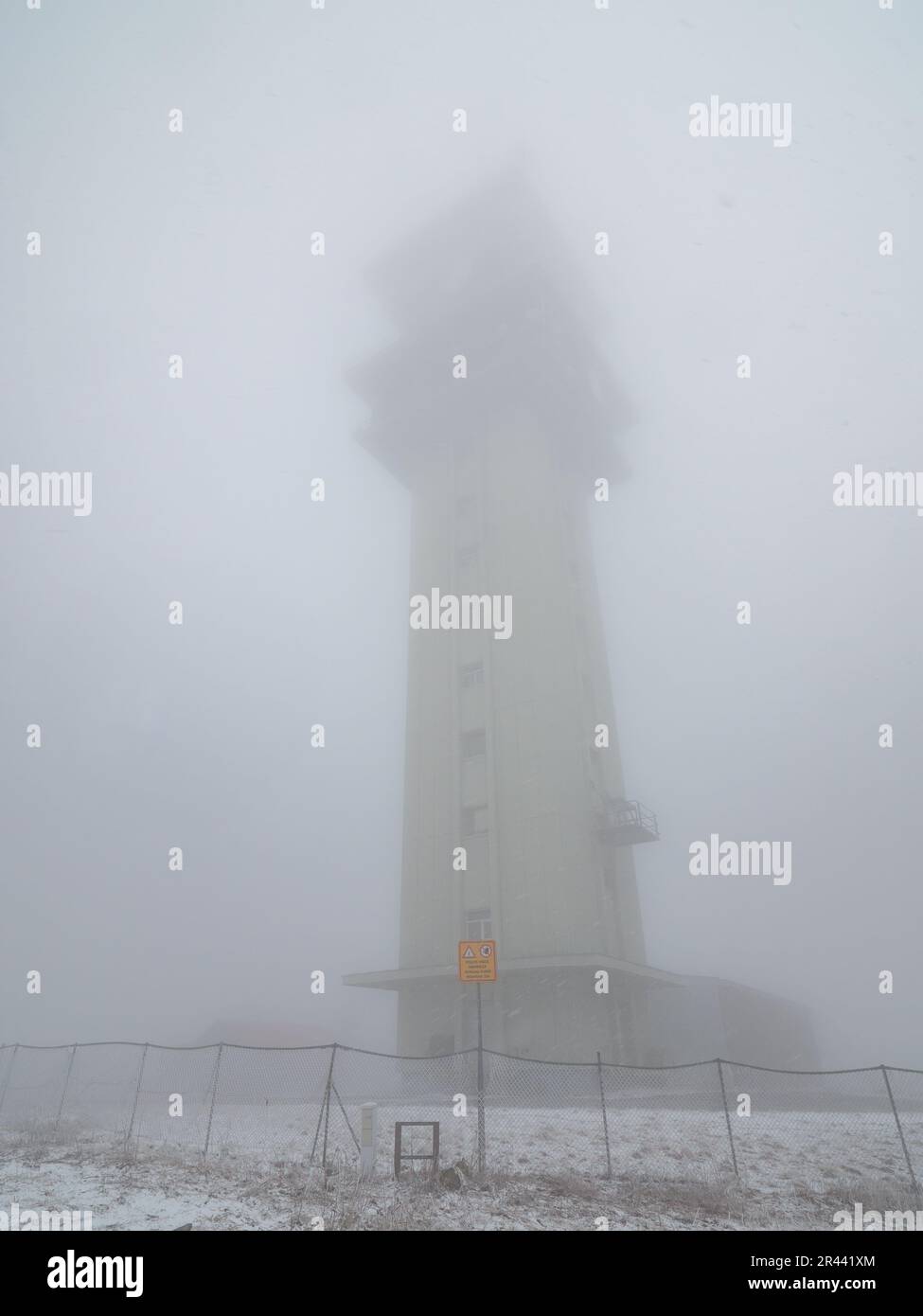 80m high radiocommunication tower in the heavy fog. The peak of the ...