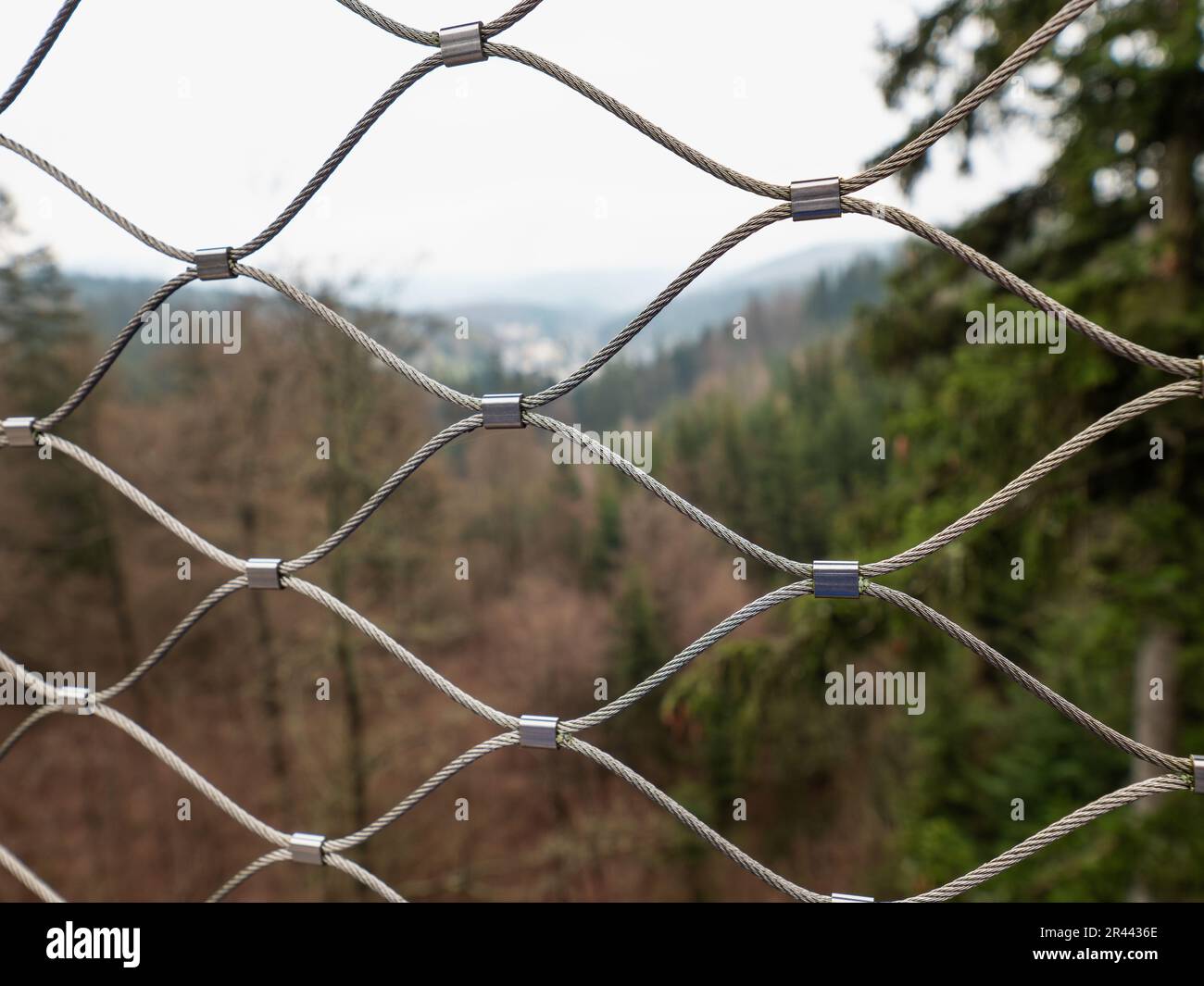 Modern chrome steel wire mesh fence with pressed joints on green ...